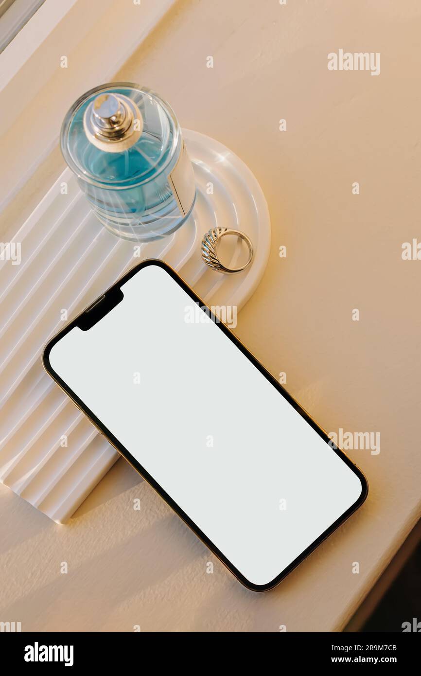 Still life composition with smartphone, perfume bottle and jewelry ring ...