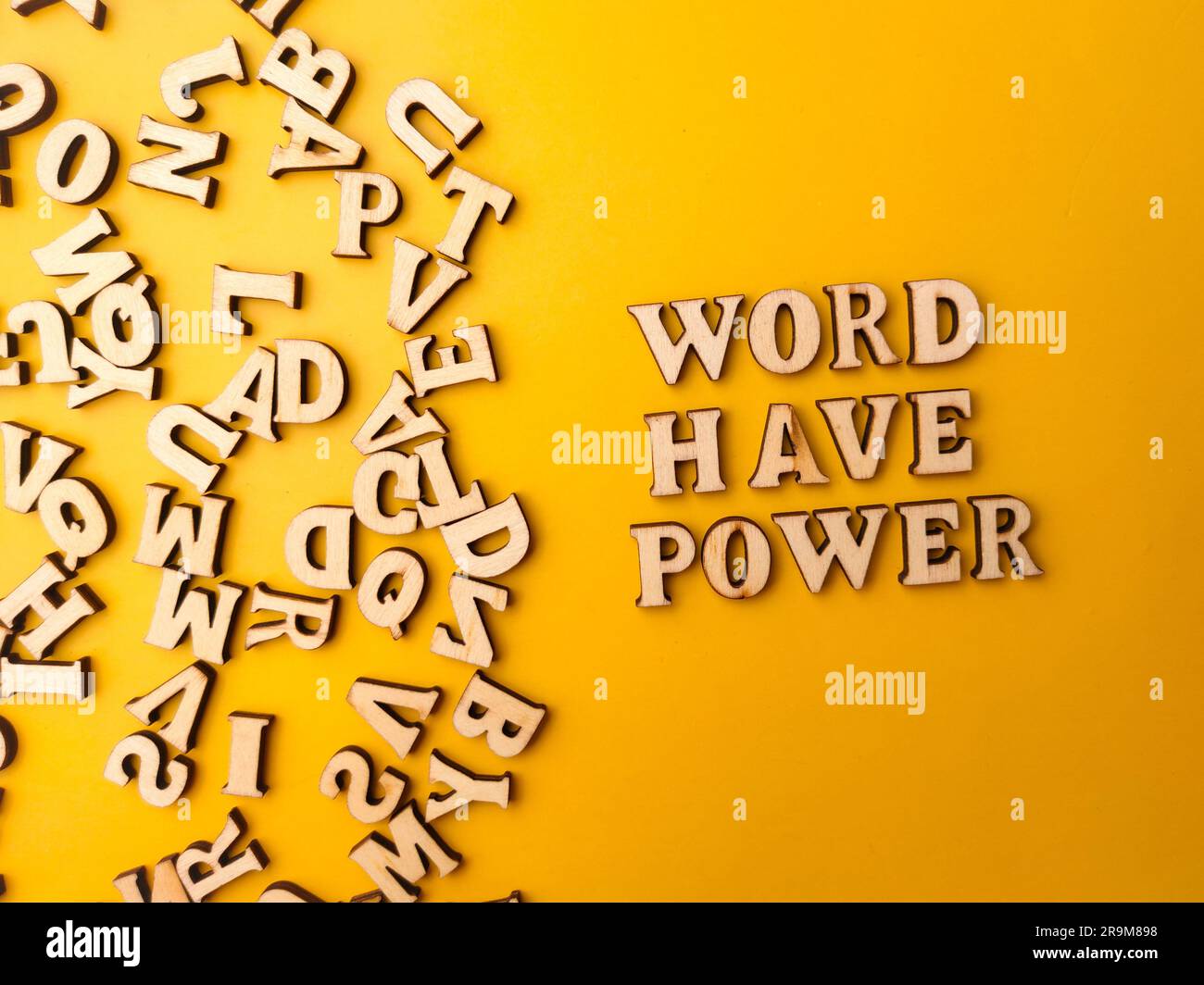 Wooden letter toy arranged the word WORD HAVE POWER with a yellow ...