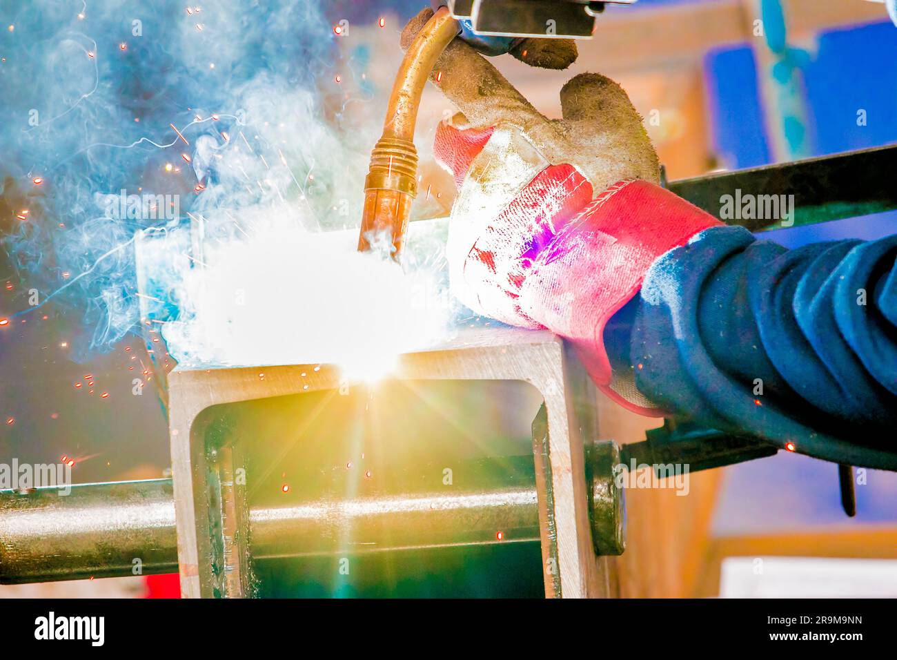 Welder cutting through metal block Stock Photo - Alamy