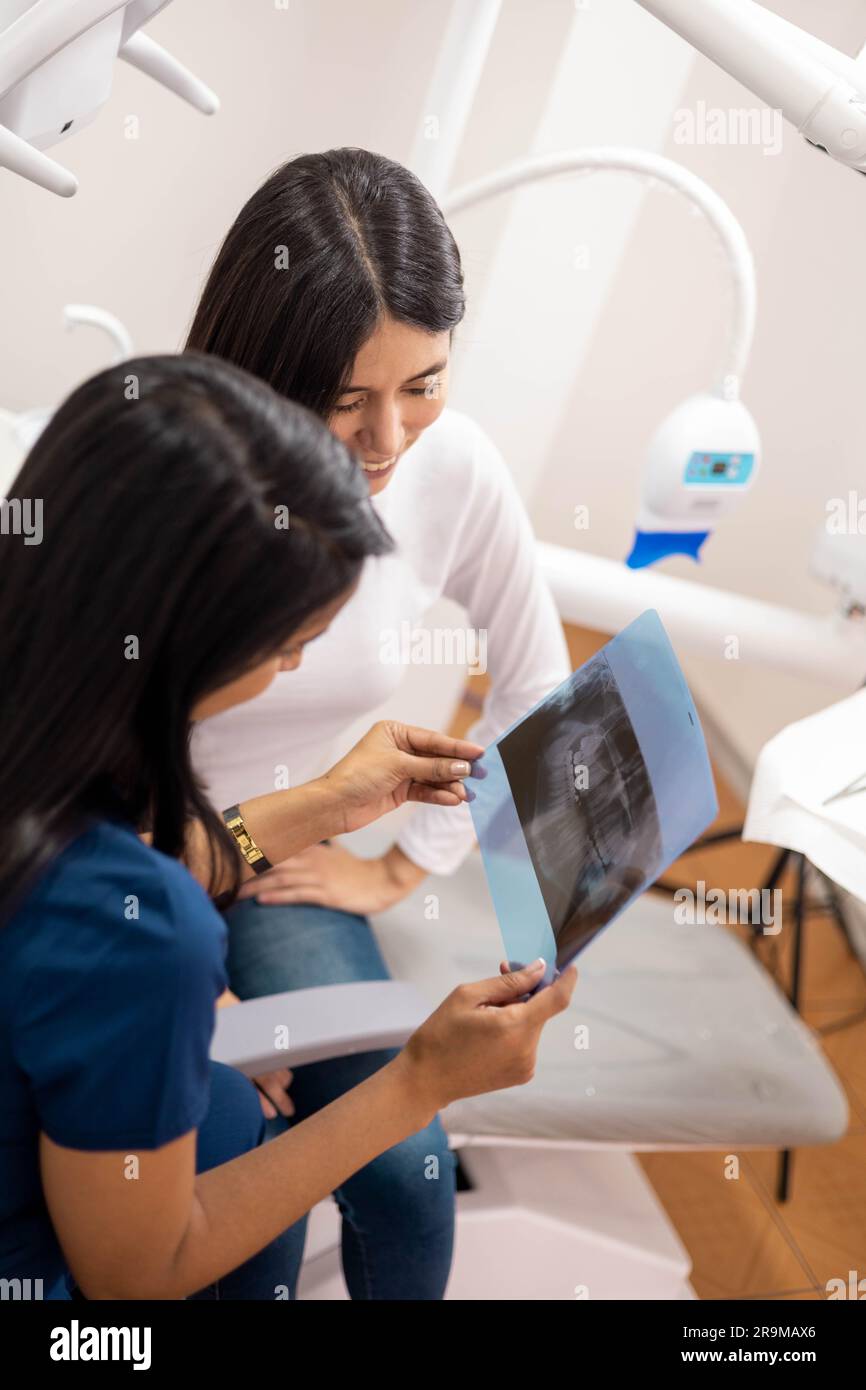 making diagnosis with x-ray images, doctor explaining treatment to her ...