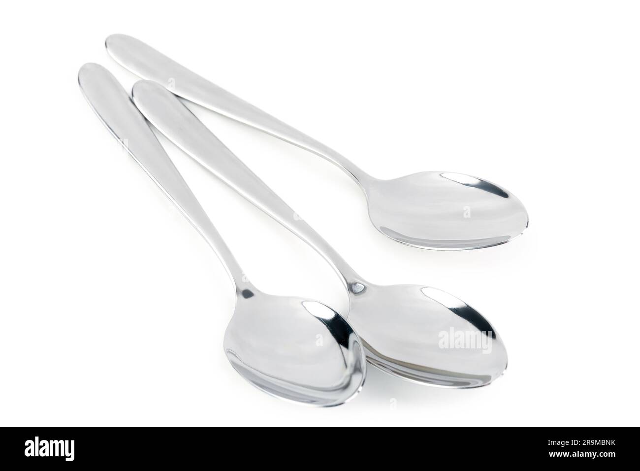 Stainless steel spoons on white background Stock Photo - Alamy