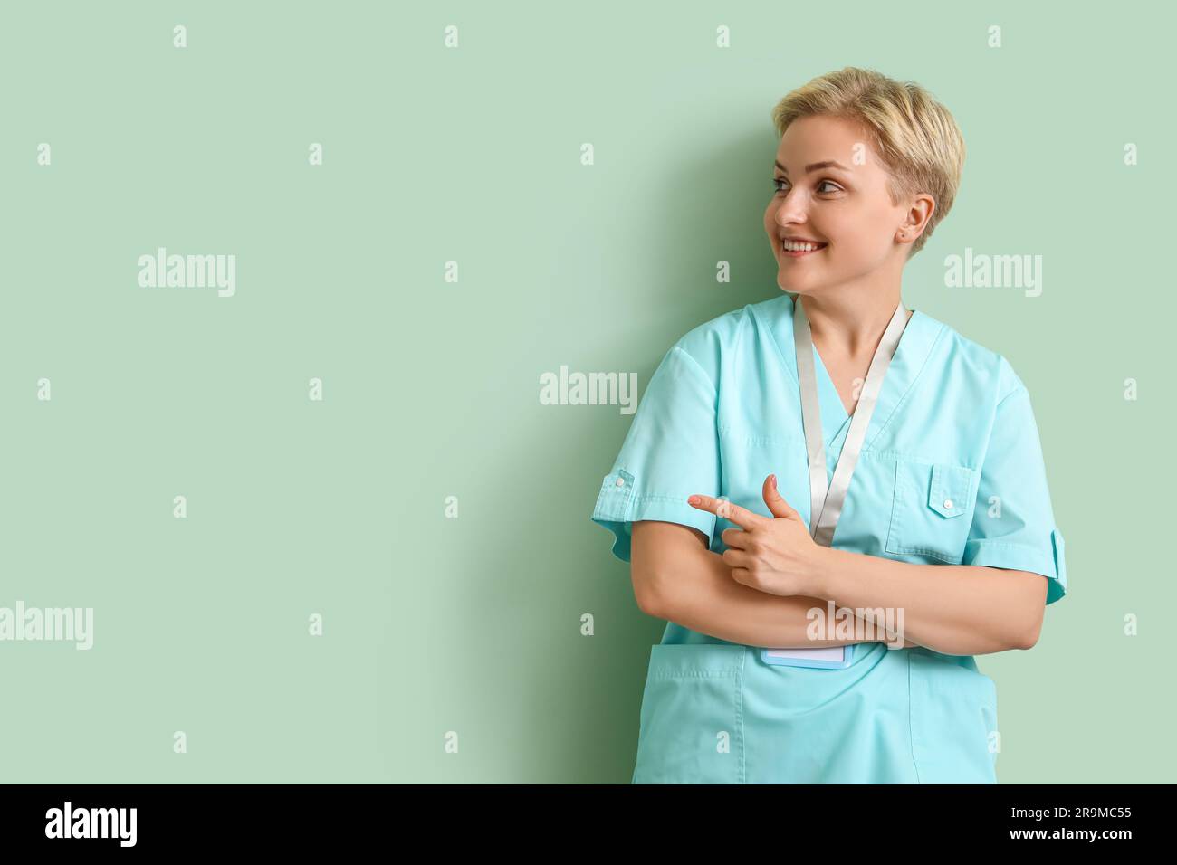 Female medical intern pointing at something on green background Stock ...