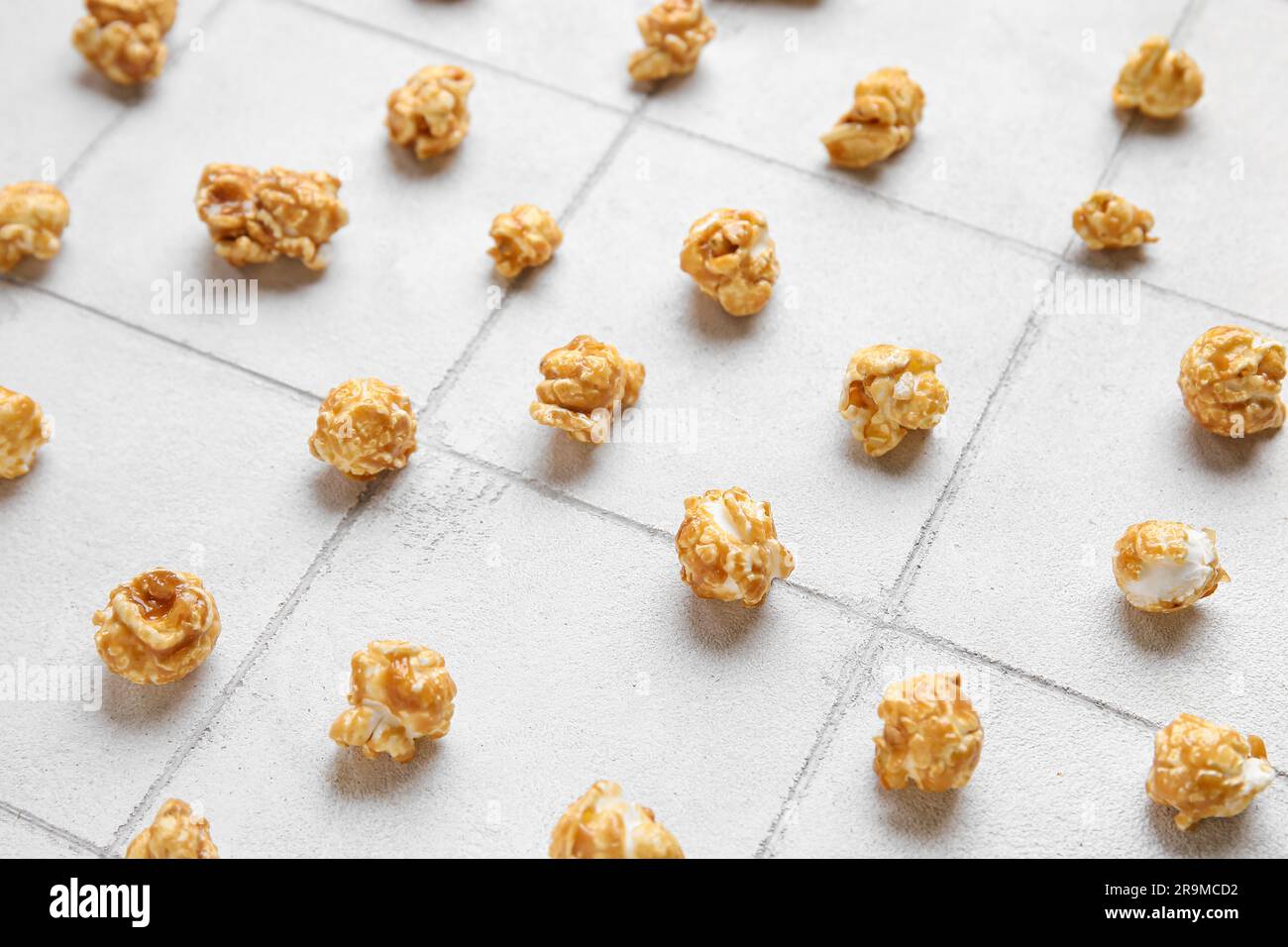 Tasty popcorn on white tile background Stock Photo - Alamy