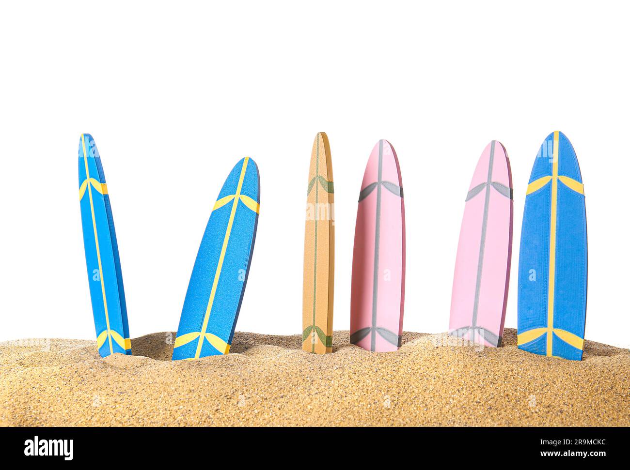 Different colorful mini surfboards on sand against white background ...