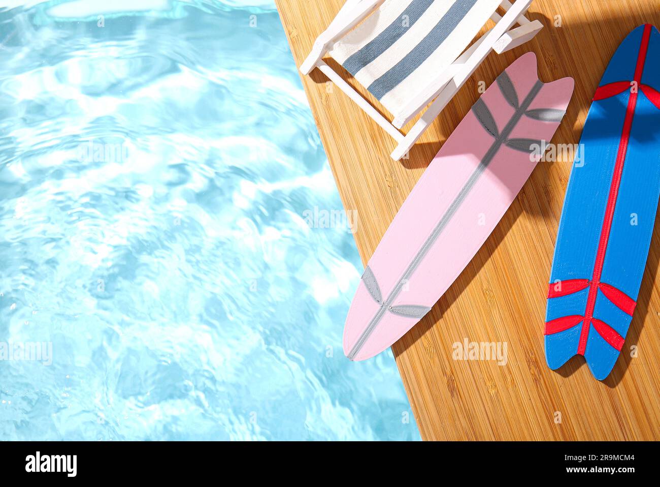 Creative composition with mini surfboards and deckchair on edge of ...
