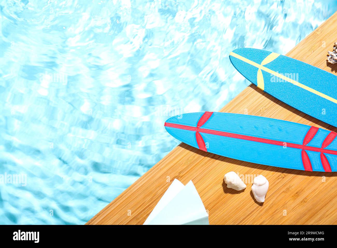 Composition with mini surfboards, umbrella and seashells on edge of ...