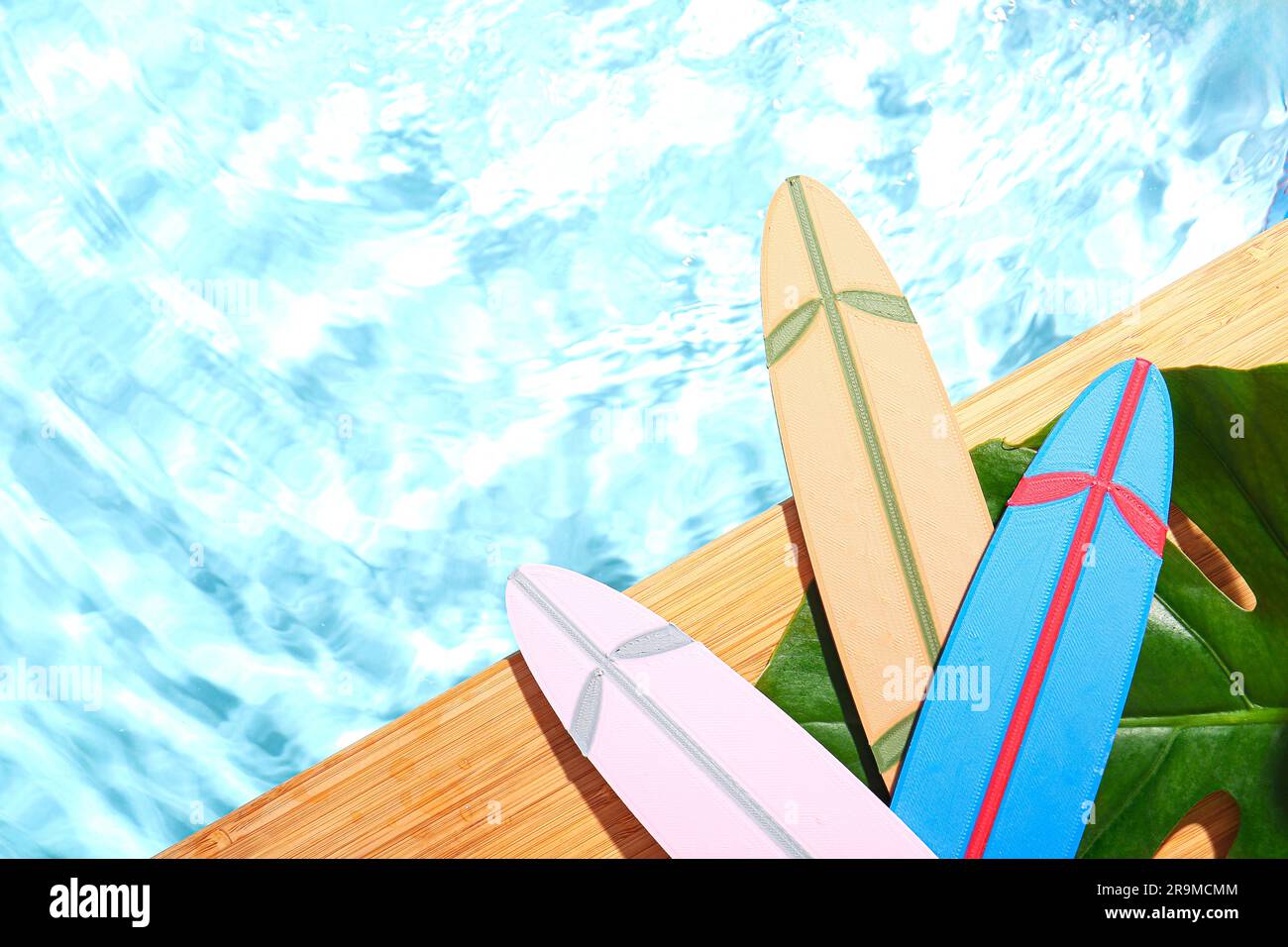 Different mini surfboards with palm leaf on edge of swimming pool Stock ...