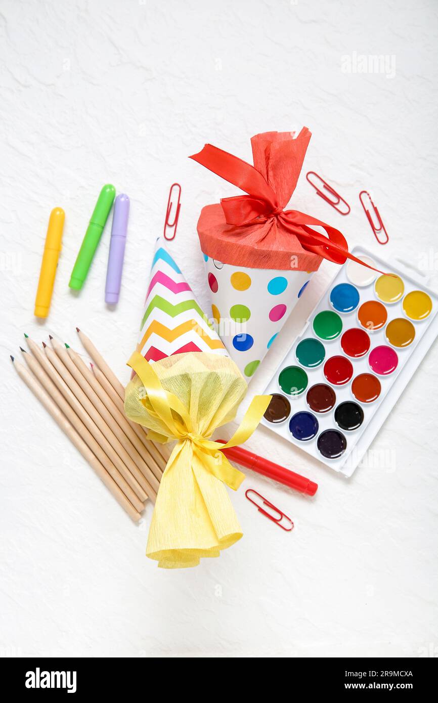 Colorful school cones with different stationery on white background ...