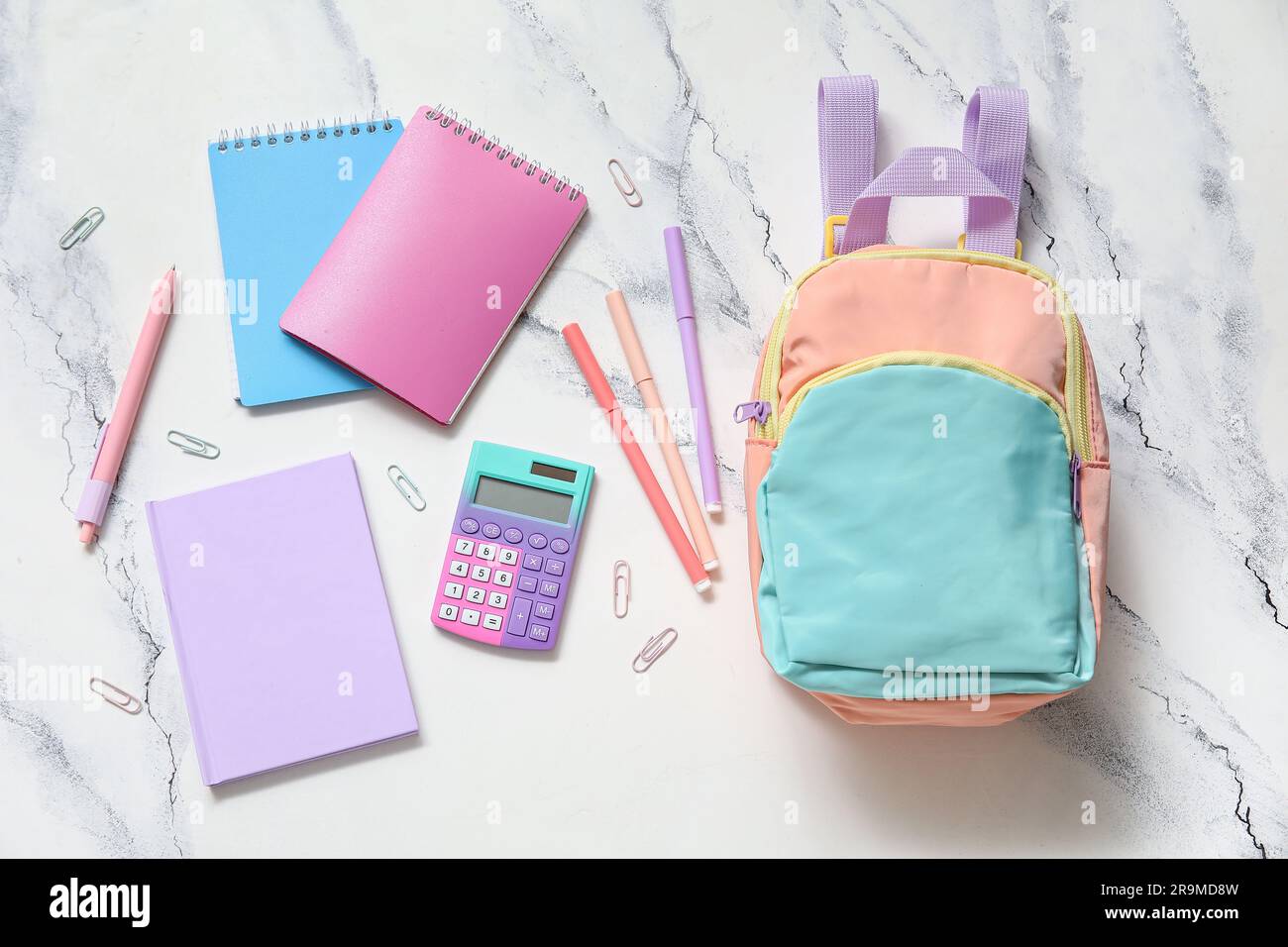 Colorful school backpack with notebooks, calculator and markers on ...