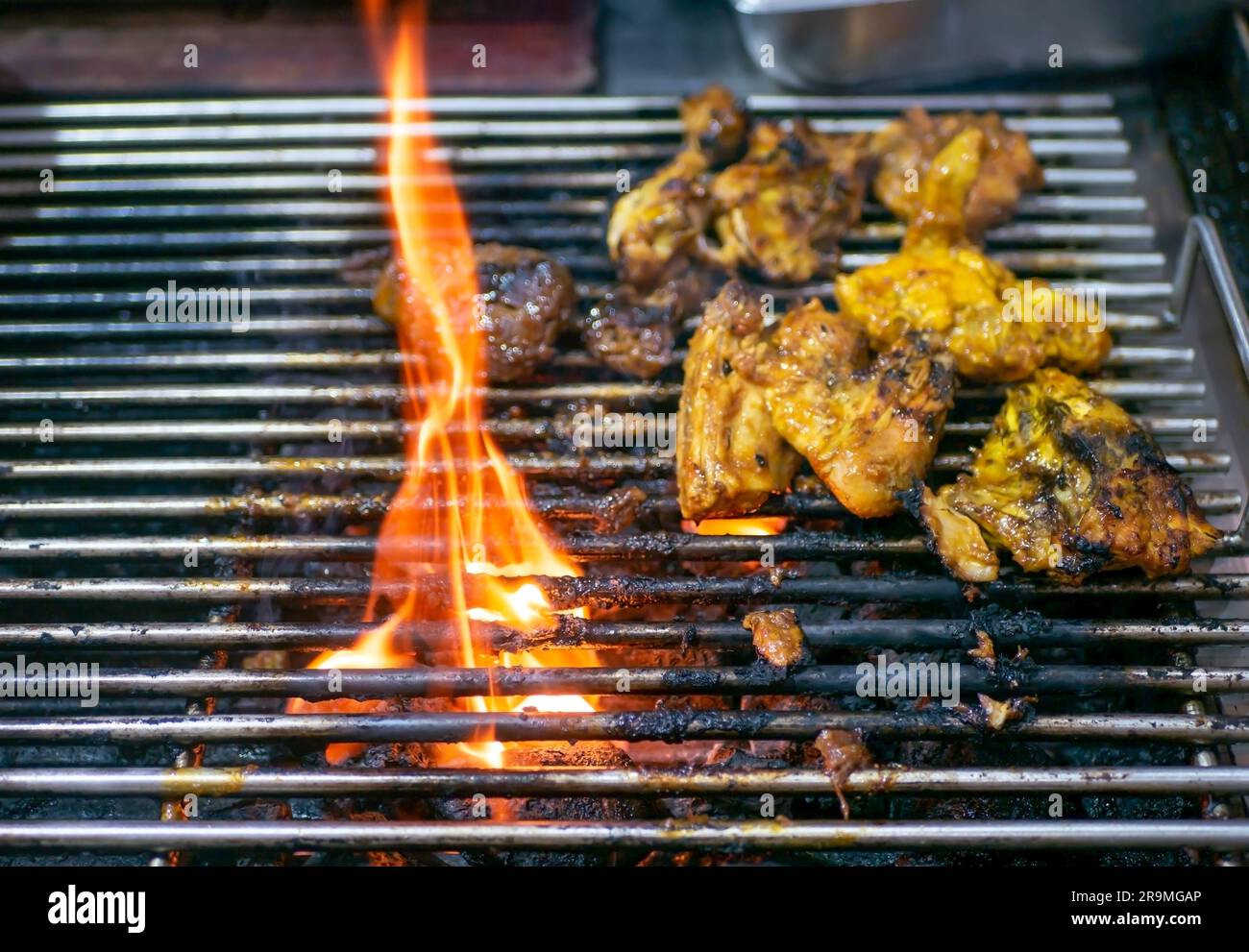 Grilled chicken with a burning fire on the grill Stock Photo - Alamy