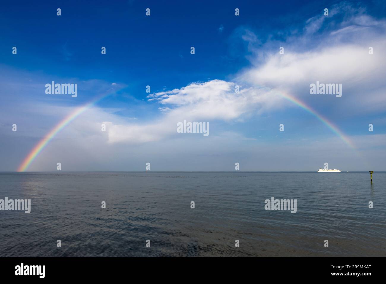 A stunning boat sailing in front of a beautiful rainbow arching over ...