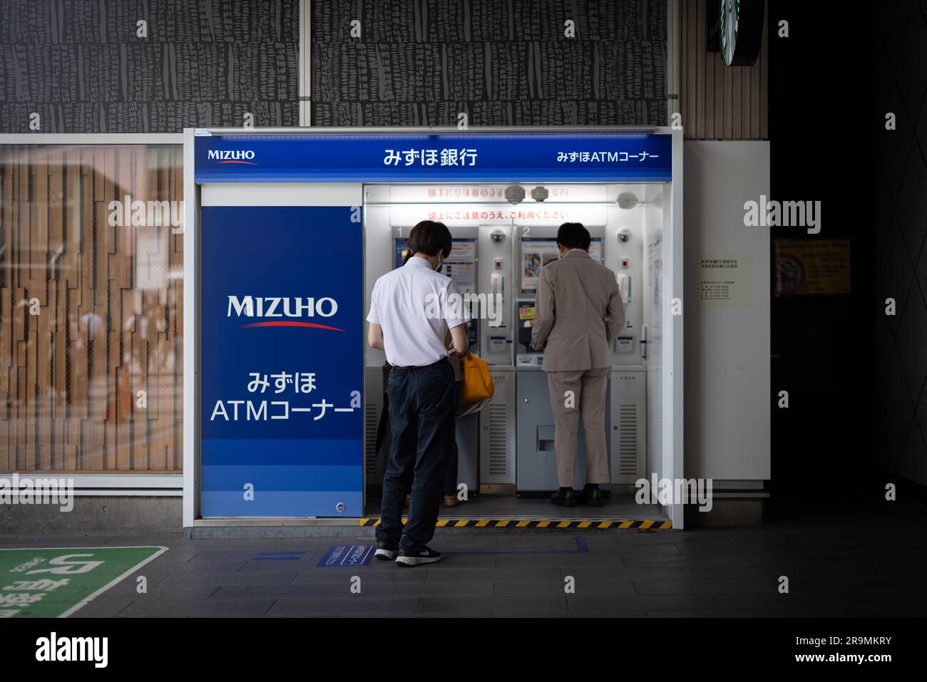 Tokyo, Japan. 27th June, 2023. Mizuho customers interact with the bank ...