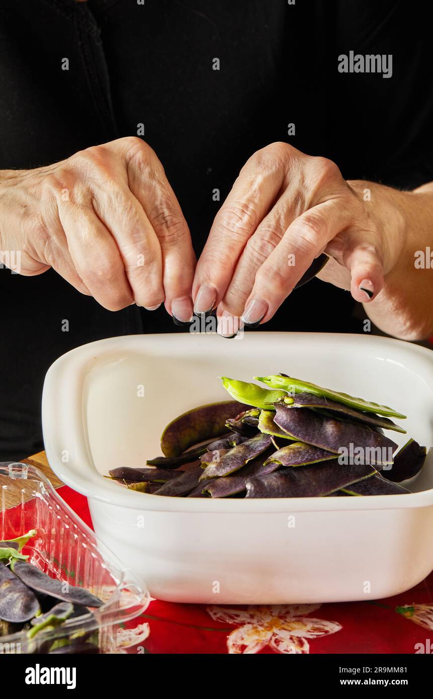 Chef peels the Purple Peas and puts them in white bowl Stock Photo - Alamy