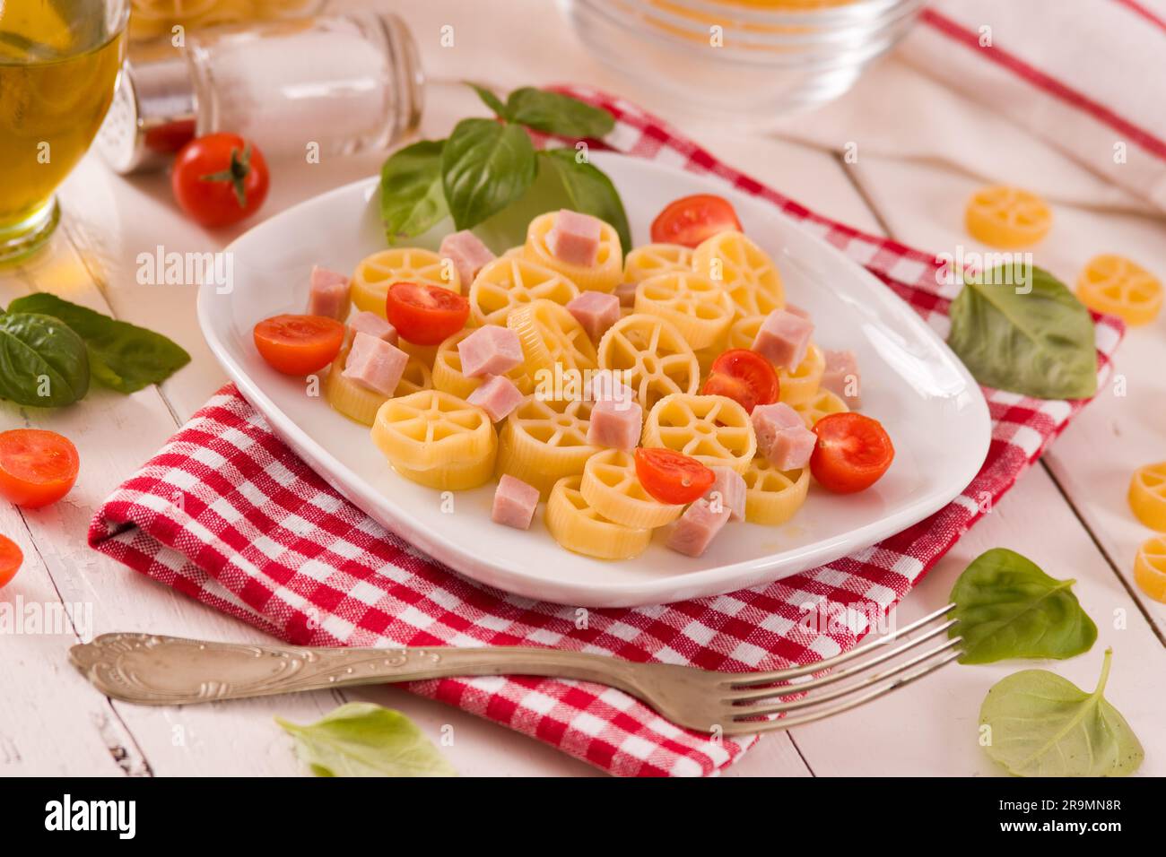 Ruote pasta with tomato and ham Stock Photo - Alamy