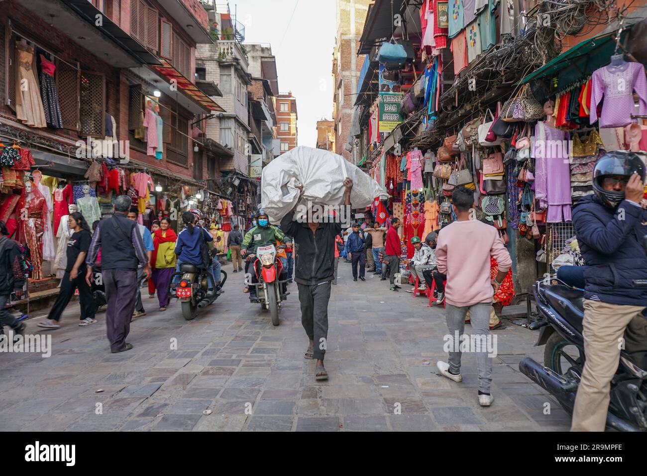 People walk and drive to their destinations in the Basantapur Durbar ...
