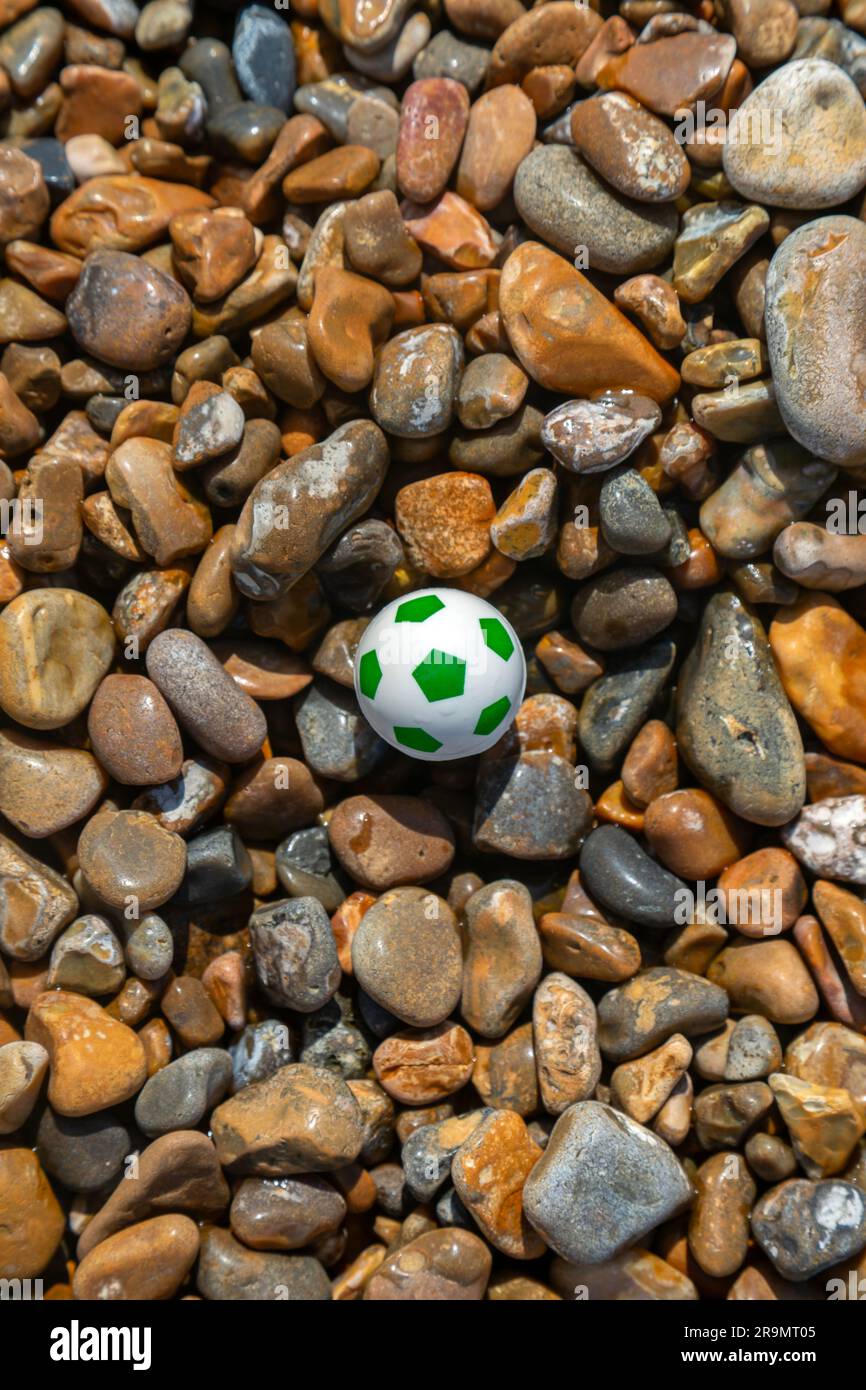 Miniature plastic football toy washed up on shingle beach, Shingle ...