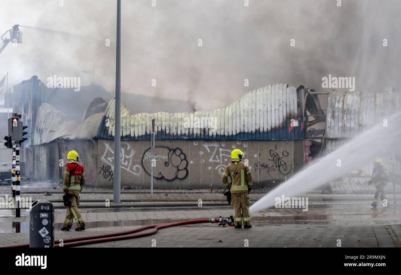 ROTTERDAM - The fire brigade extinguishes a large fire in a shed on ...