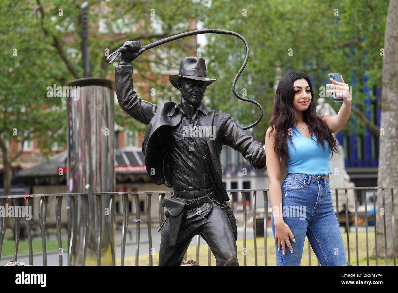 A person taking a selfie with a life-sized bronze statue of the ...