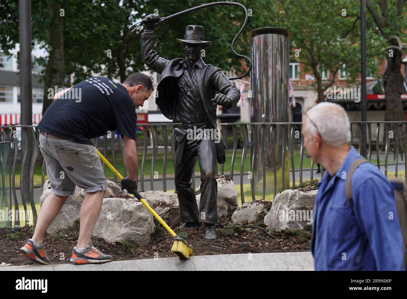 A life-sized bronze statue of the character Indiana Jones being cleaned ...