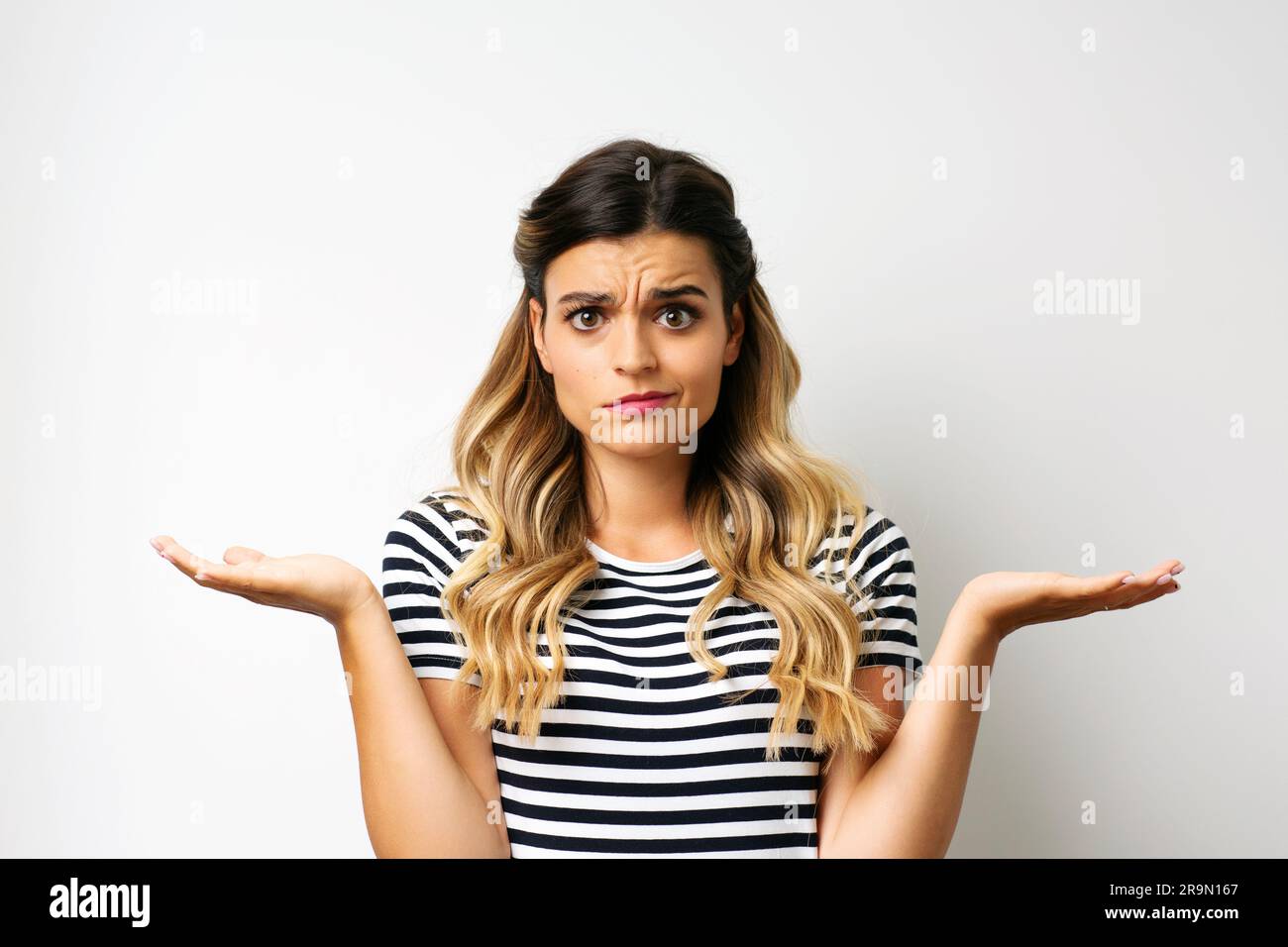 decision making confused young woman with hands on side makes scale ...