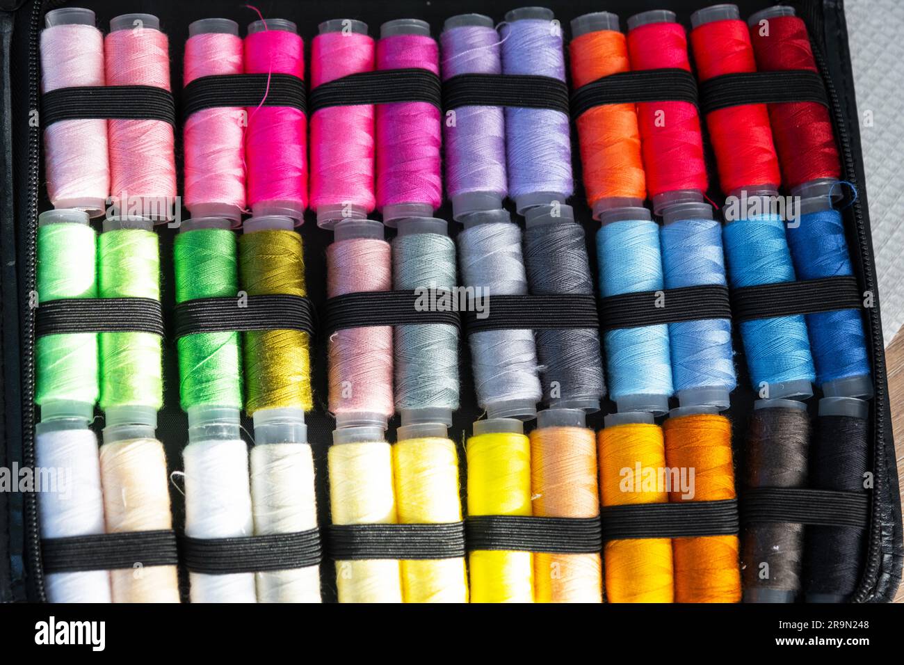 Sewing layout with multicolored spools of thread close-up, needles ...