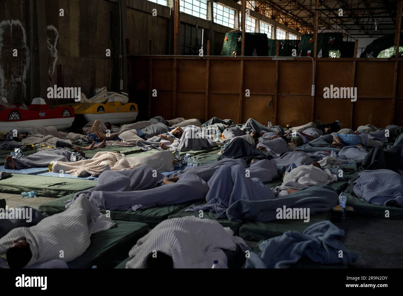 FILE - Survivors of a shipwreck sleep at a warehouse at the port in ...