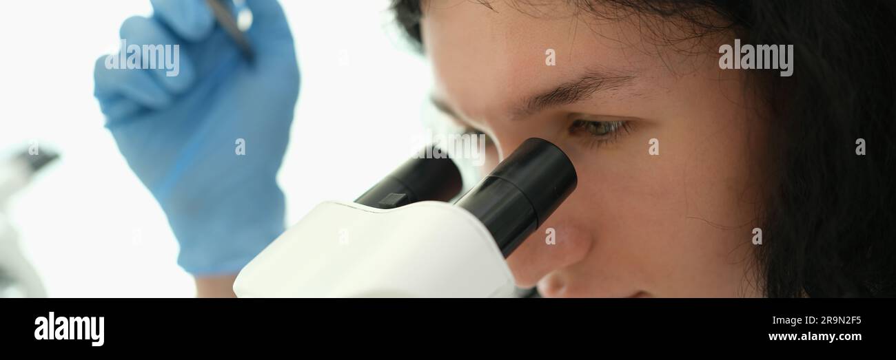 Laboratory diagnostics doctor looking into microscope and making blood ...