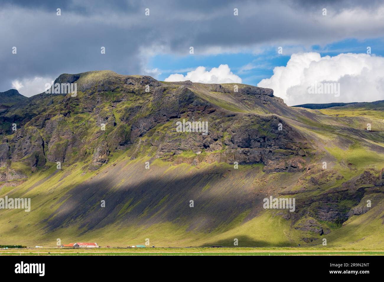 Southern Iceland and landscape with clouds and their shadows casted on the steep hills. Travel ...