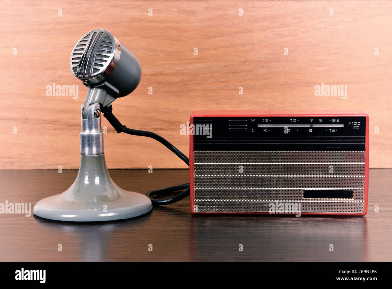 Red vintage radio and retro microphone on wooden table. Vintage effect ...