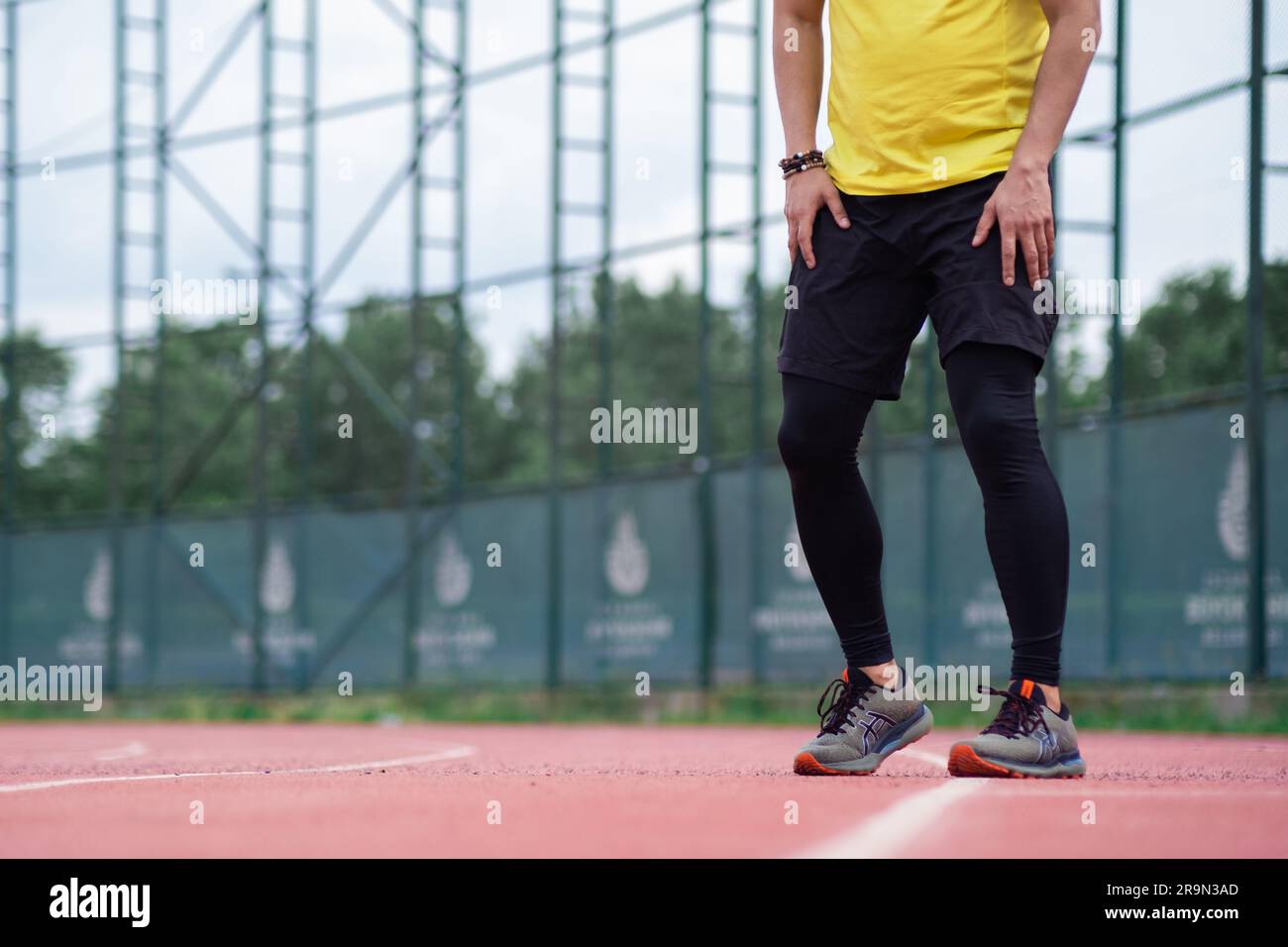Sportsman in leggings and shorts training on running track on urban ...