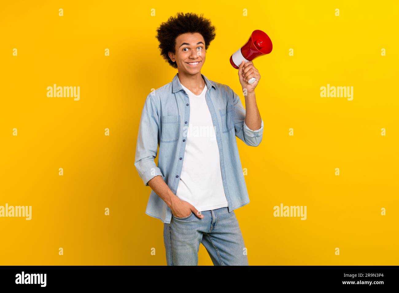 Photo of cheerful positive guy dressed denim shirt rising loud speaker ...