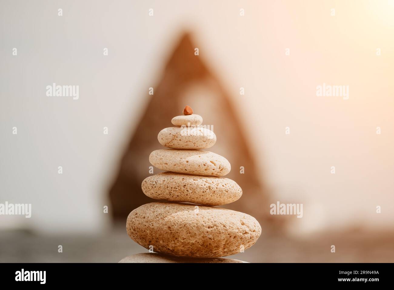 balanced rock pyramid stands tall on sea pebble beach. Selective focus ...