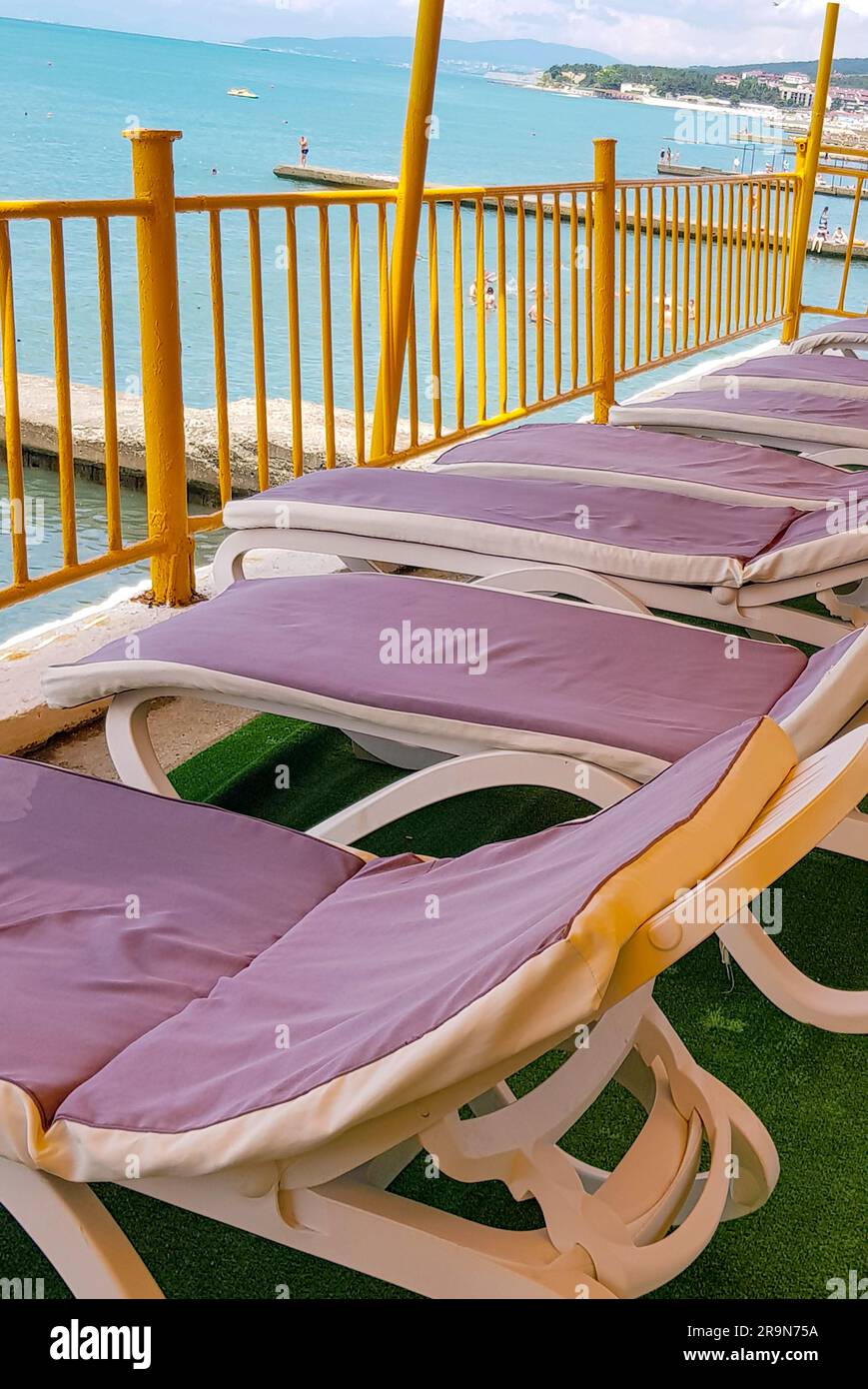 Free deck chairs stand in a row, empty beach chairs are waiting for ...
