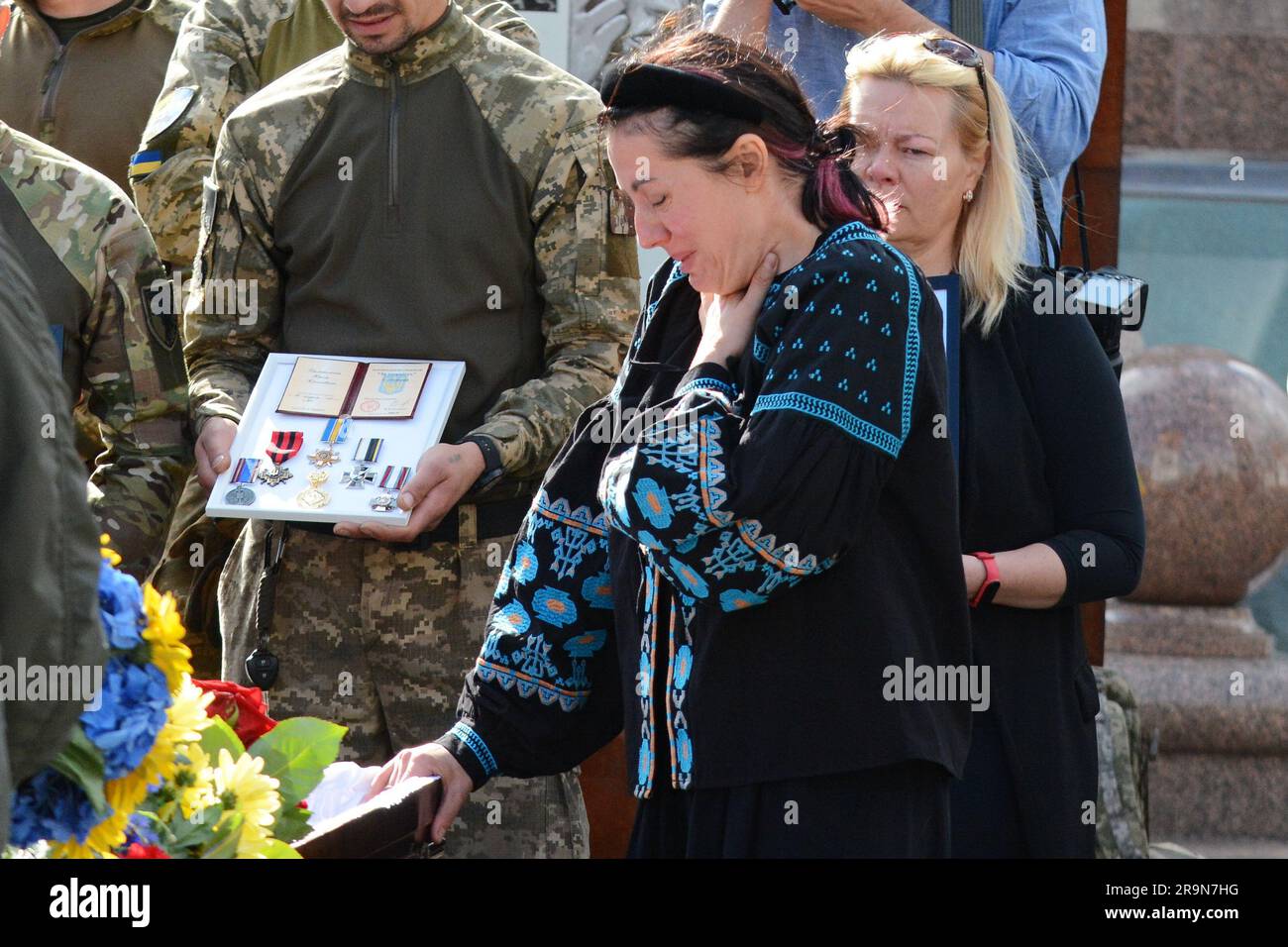 Kyiv, Ukraine. 28th June, 2023. A woman cries next to the coffin with ...
