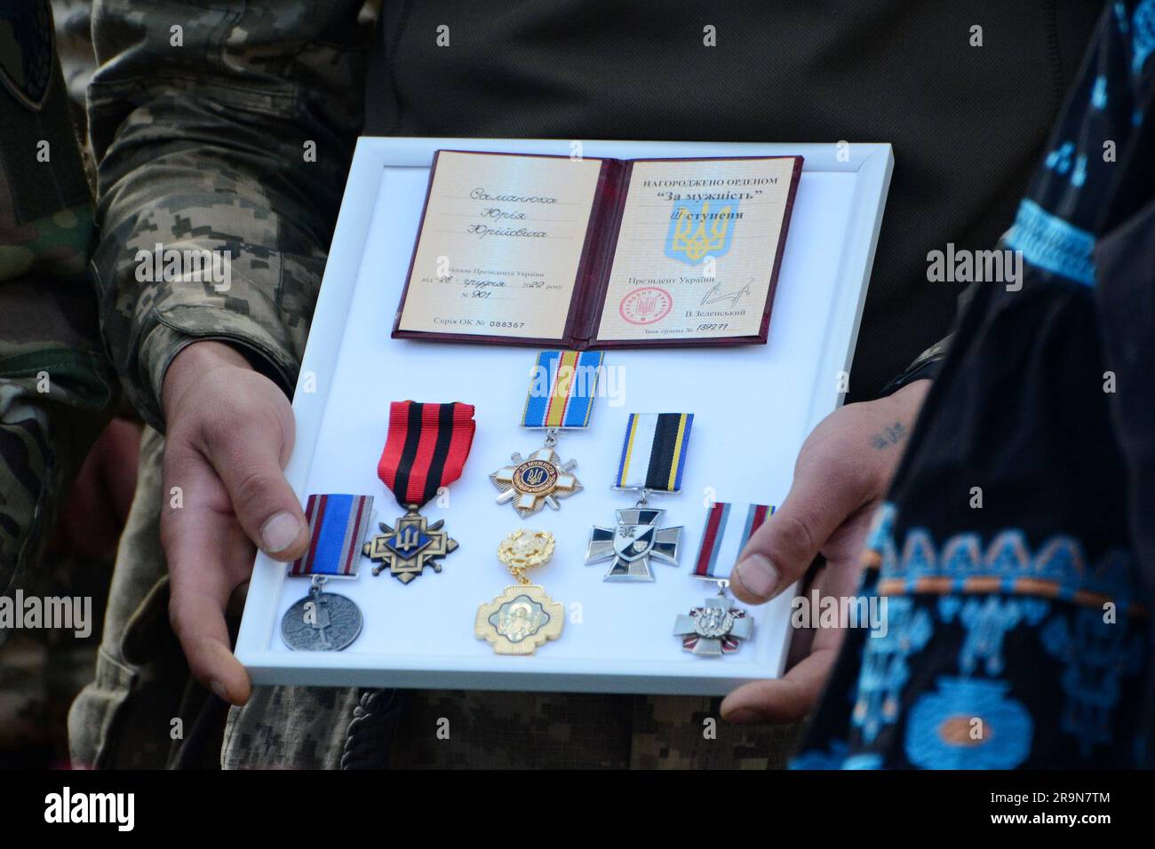 Kyiv, Ukraine. 28th June, 2023. A military man holds awards next to the ...
