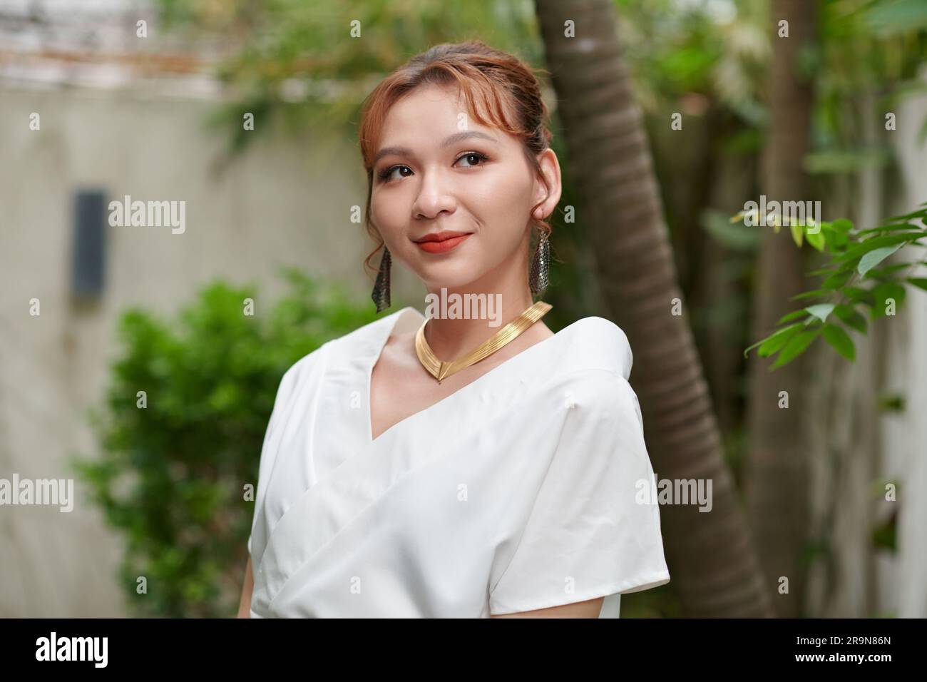 Portrait of smiling elegant transgender woman dress for event standing ...
