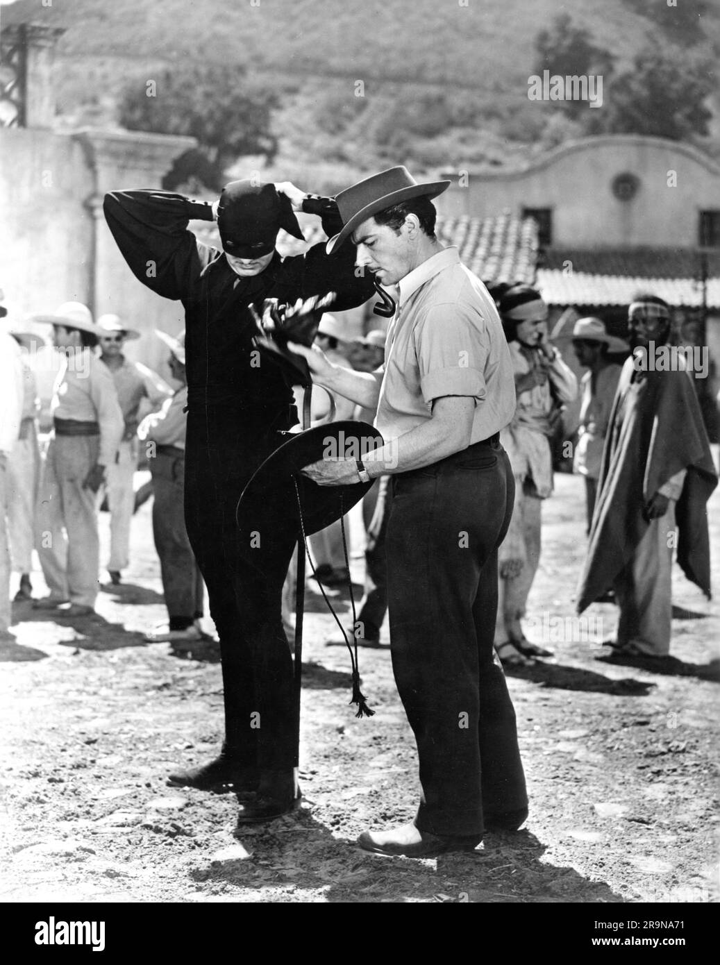 TYRONE POWER on set candid with wardrobe expert EDDIE ARMAND on set ...
