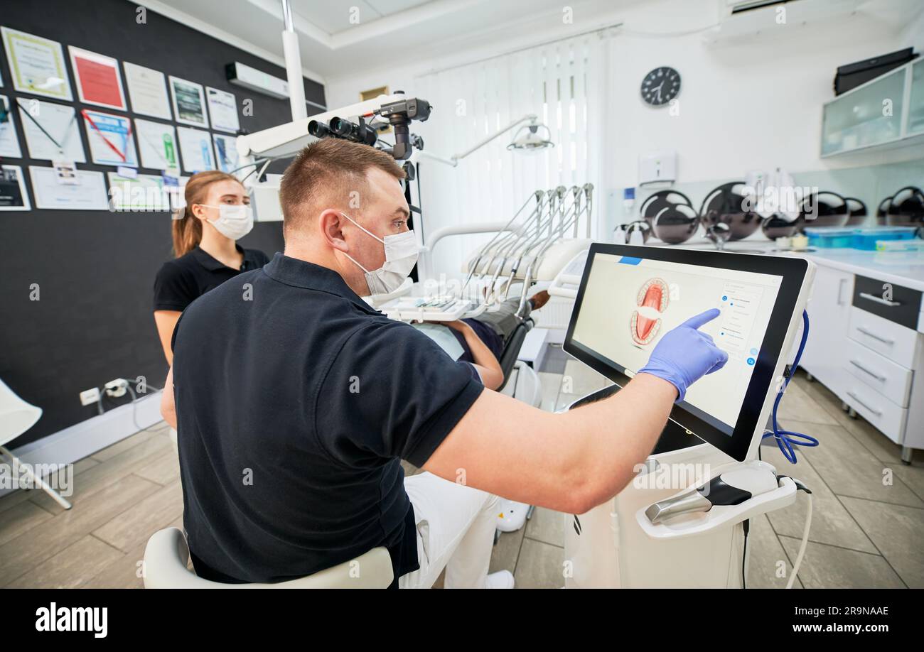 Dentist scanning patient's teeth with modern machine for intraoral ...