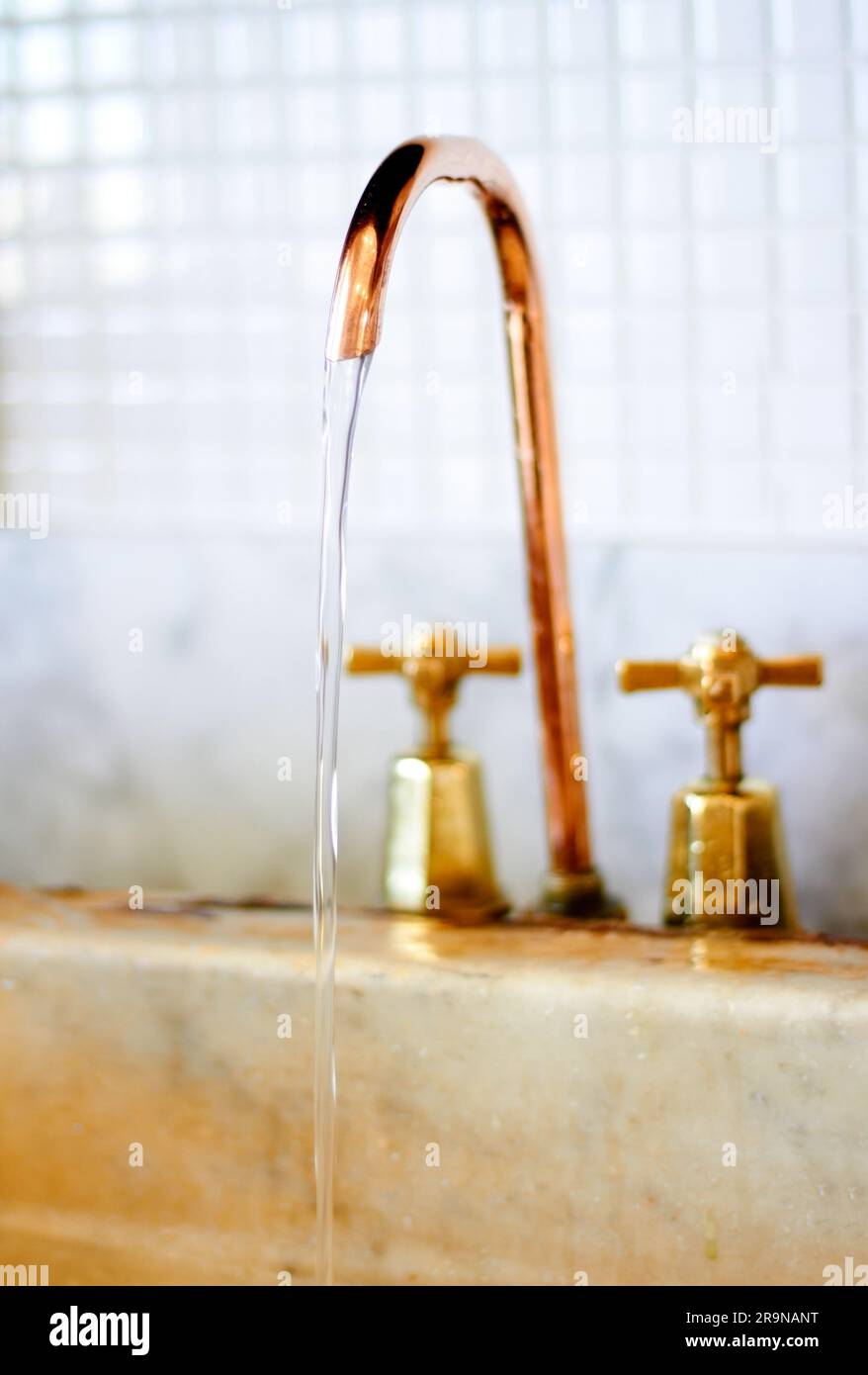 Faucet, copper and tap with water running for cleaning, washing and ...