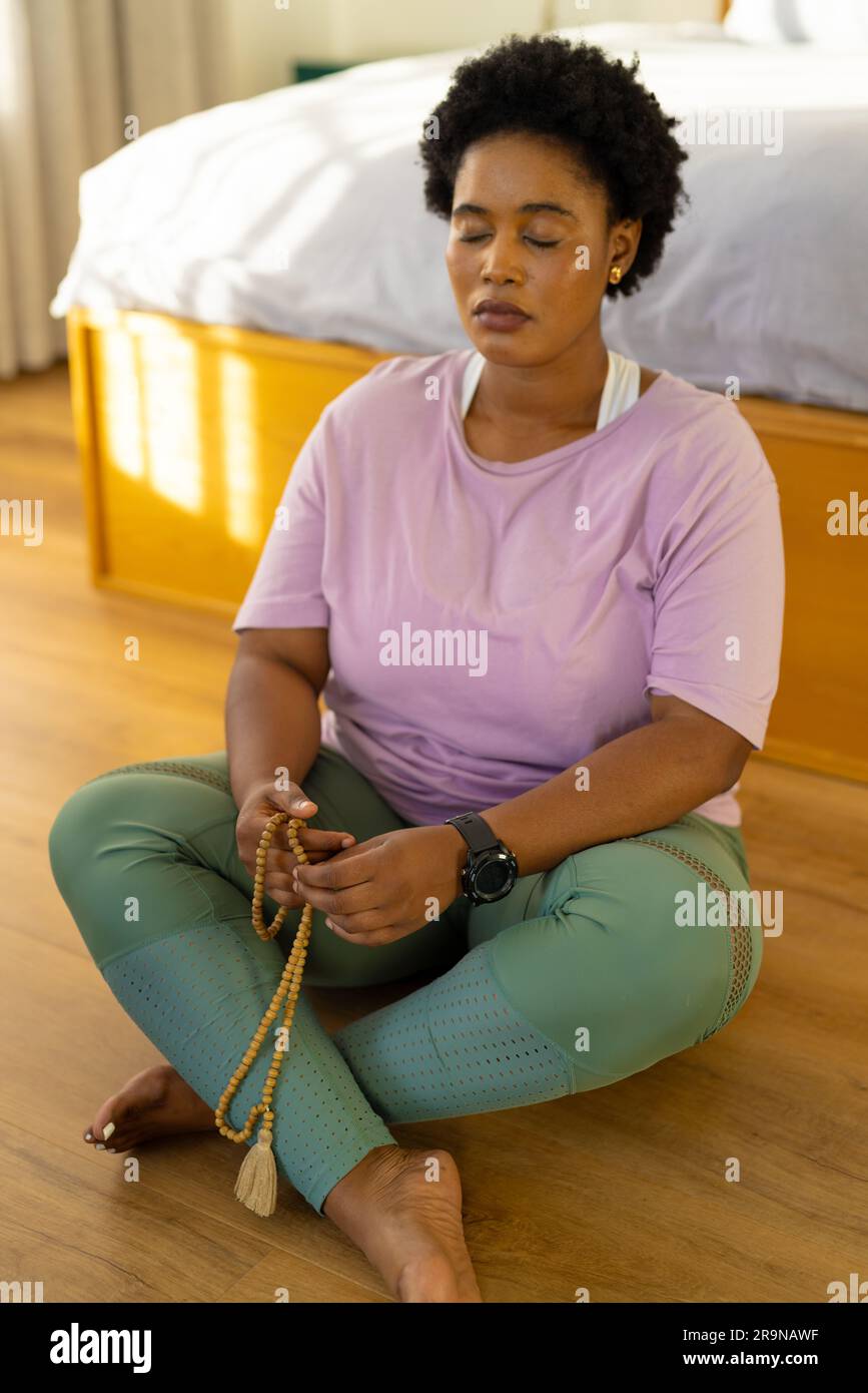 Focused plus size african american woman practicing yoga meditation at ...