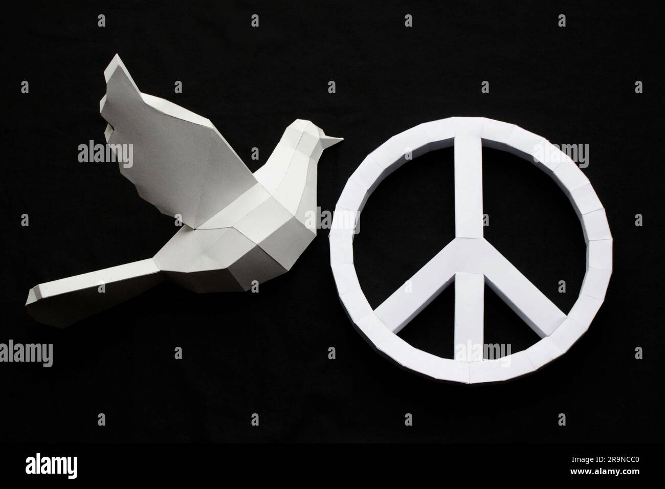 Paper Peace sign and paper dove on a black background, a symbol of ...