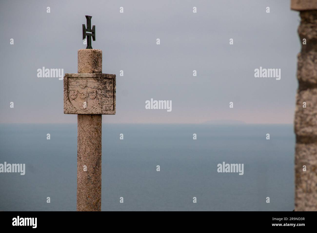 iron cross with the coat of arms of Portugal carved in stone on a ...