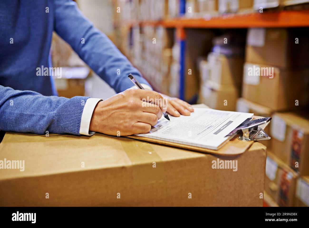 Hands, sign and clipboard with factory with boxes, clipboard and supply ...