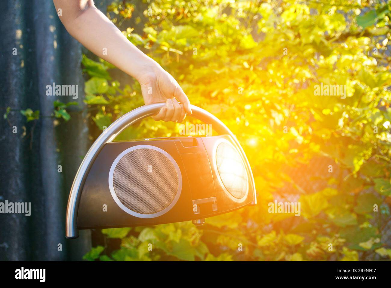A hand holds a retro boombox, creating a nostalgic scene against a ...