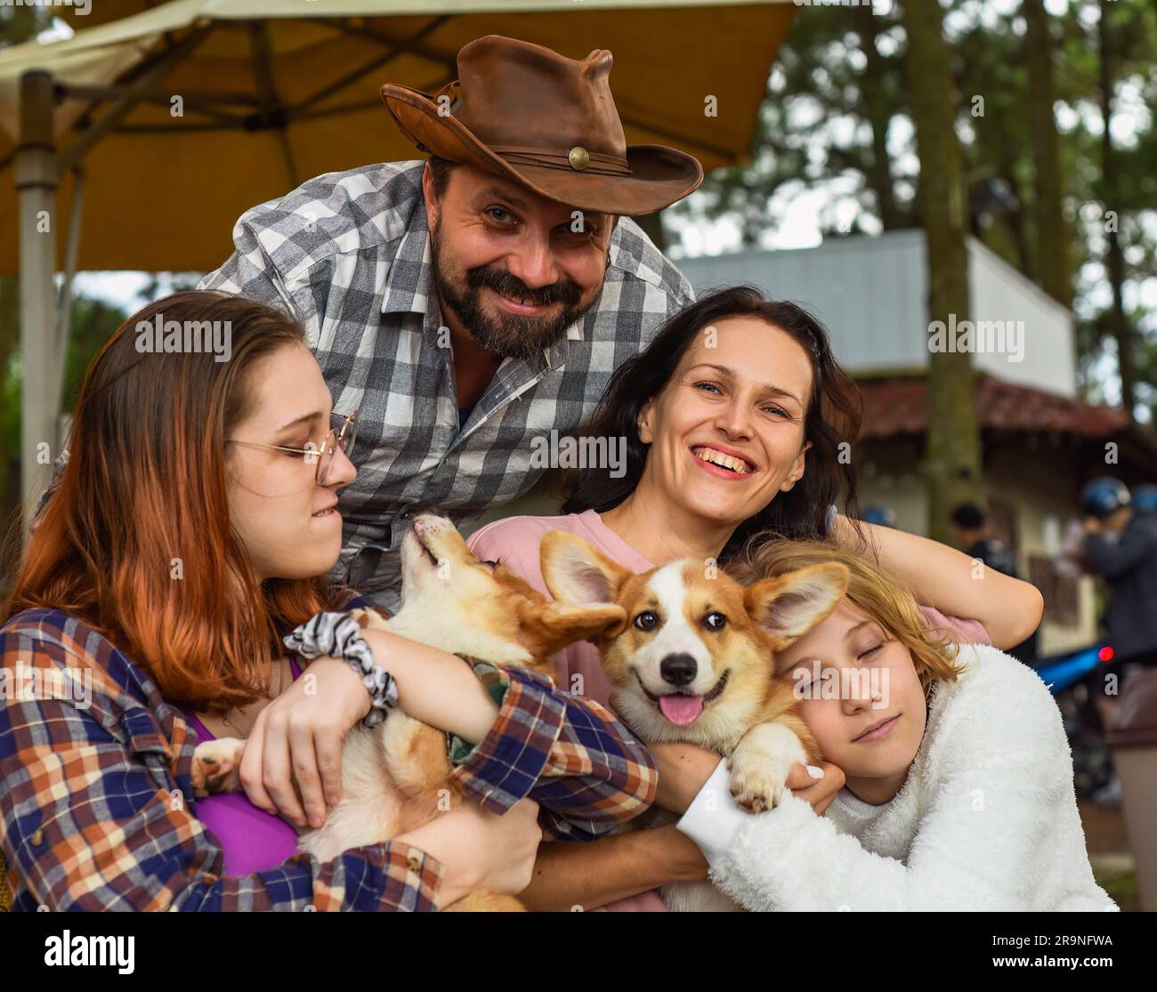 Family members father, mother and two daughters with corgi dogs in the forest Stock Photo - Alamy