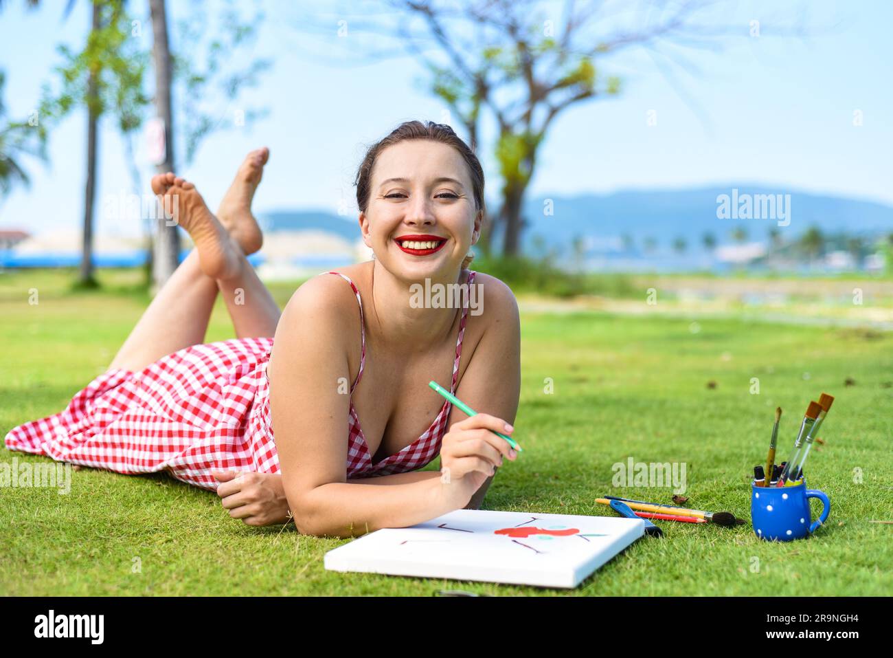 Young woman artist and illustrator drawing witha pencil, laying on a ...