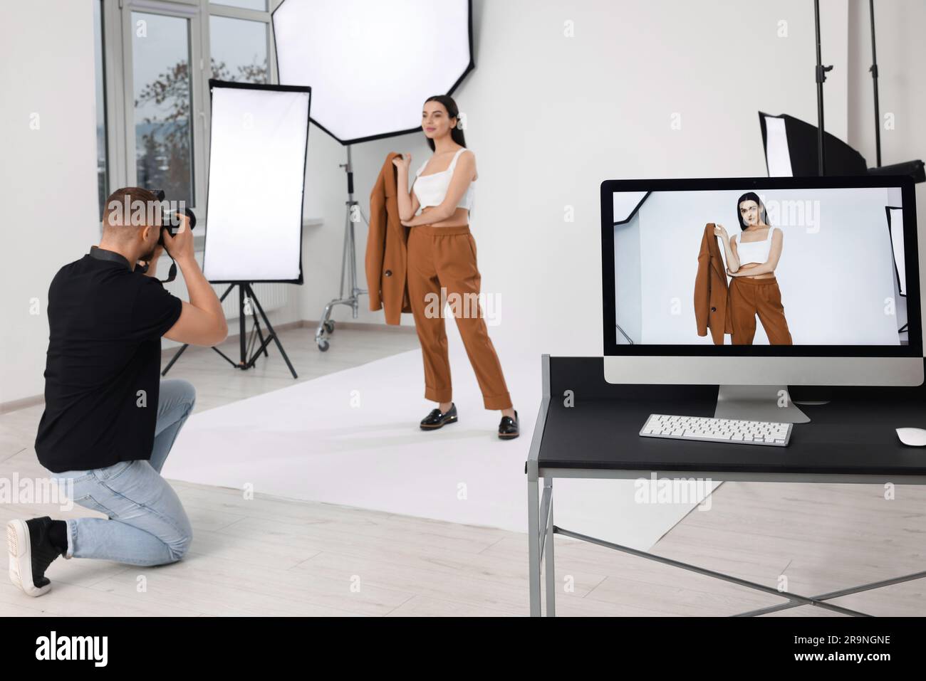 Professional photographer working with beautiful model in modern photo ...