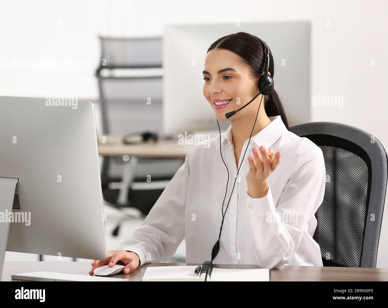 Hotline operator with headset working on computer in office Stock Photo ...