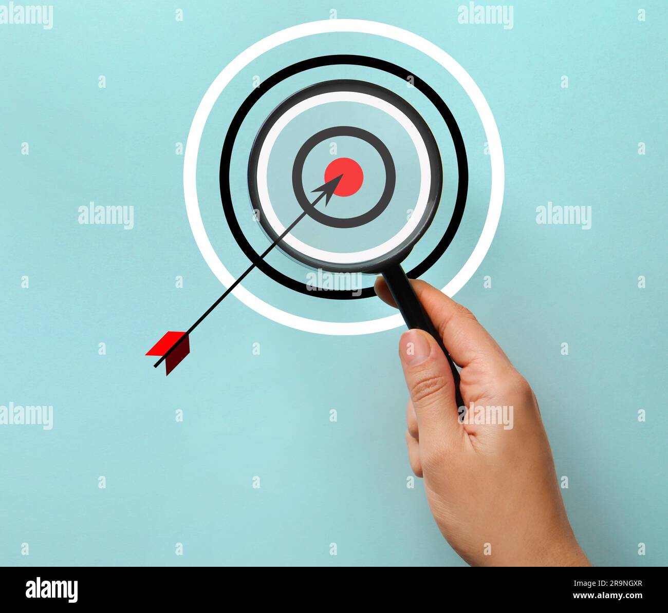 Woman holding magnifying glass on light blue background, closeup ...