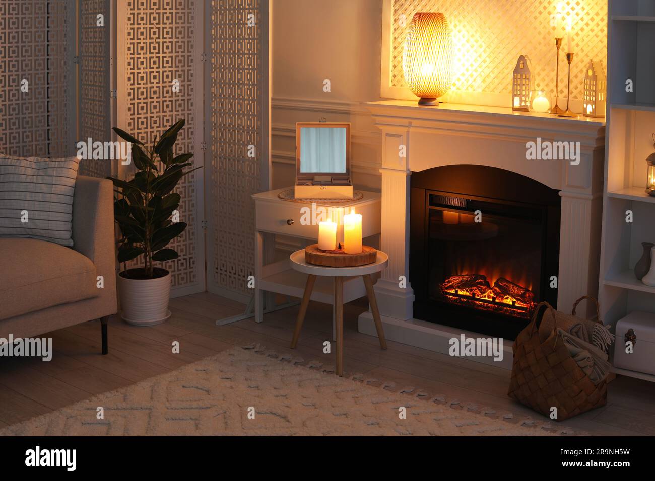 Beautiful fireplace and different decor in living room at night ...